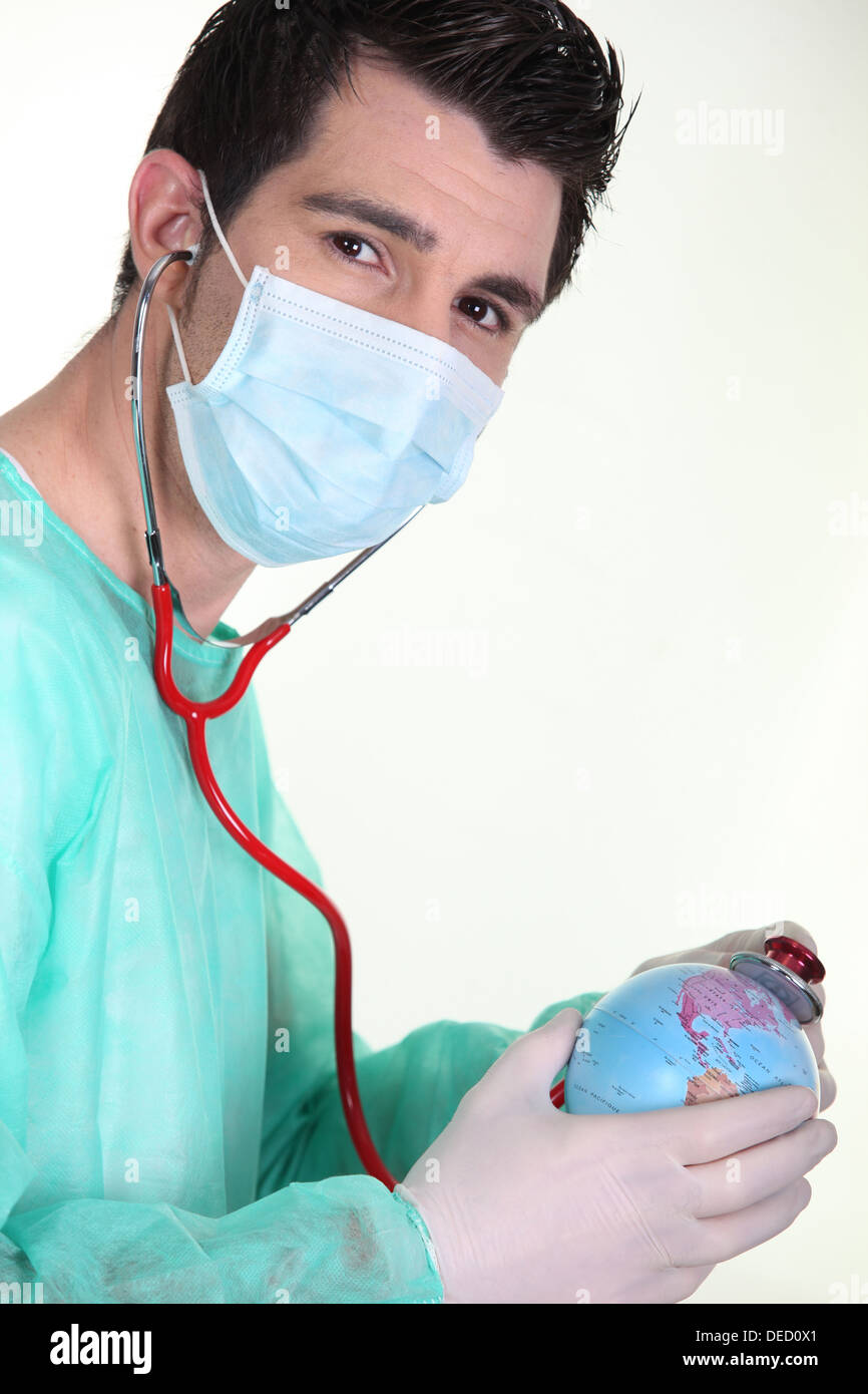 Doctor using stethoscope on globe Stock Photo - Alamy