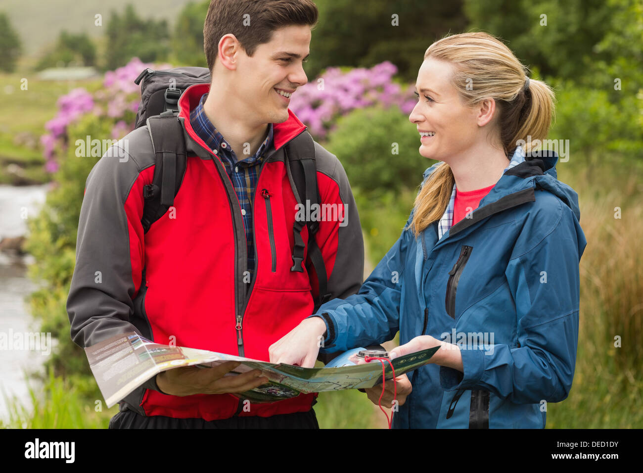 Happy couple reading map on a hike Stock Photo - Alamy