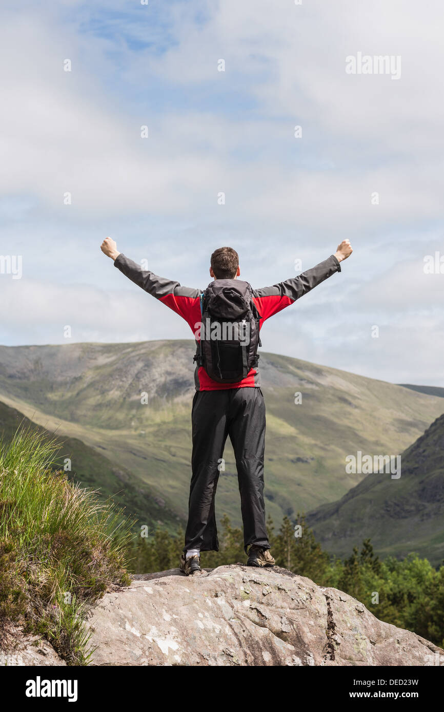 Man standing at hill top cheering Stock Photo - Alamy