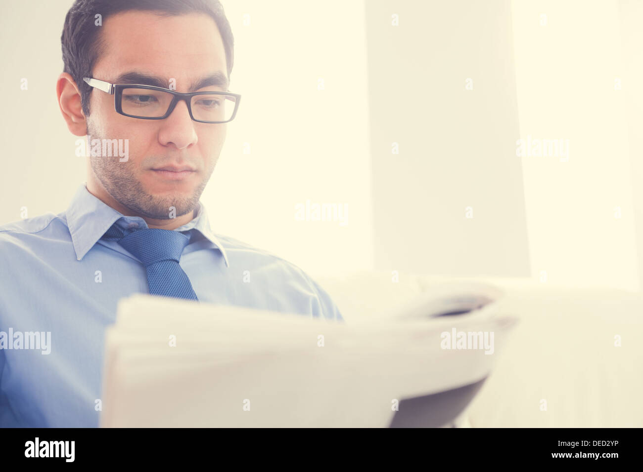 Serious man reading a newspaper Stock Photo - Alamy