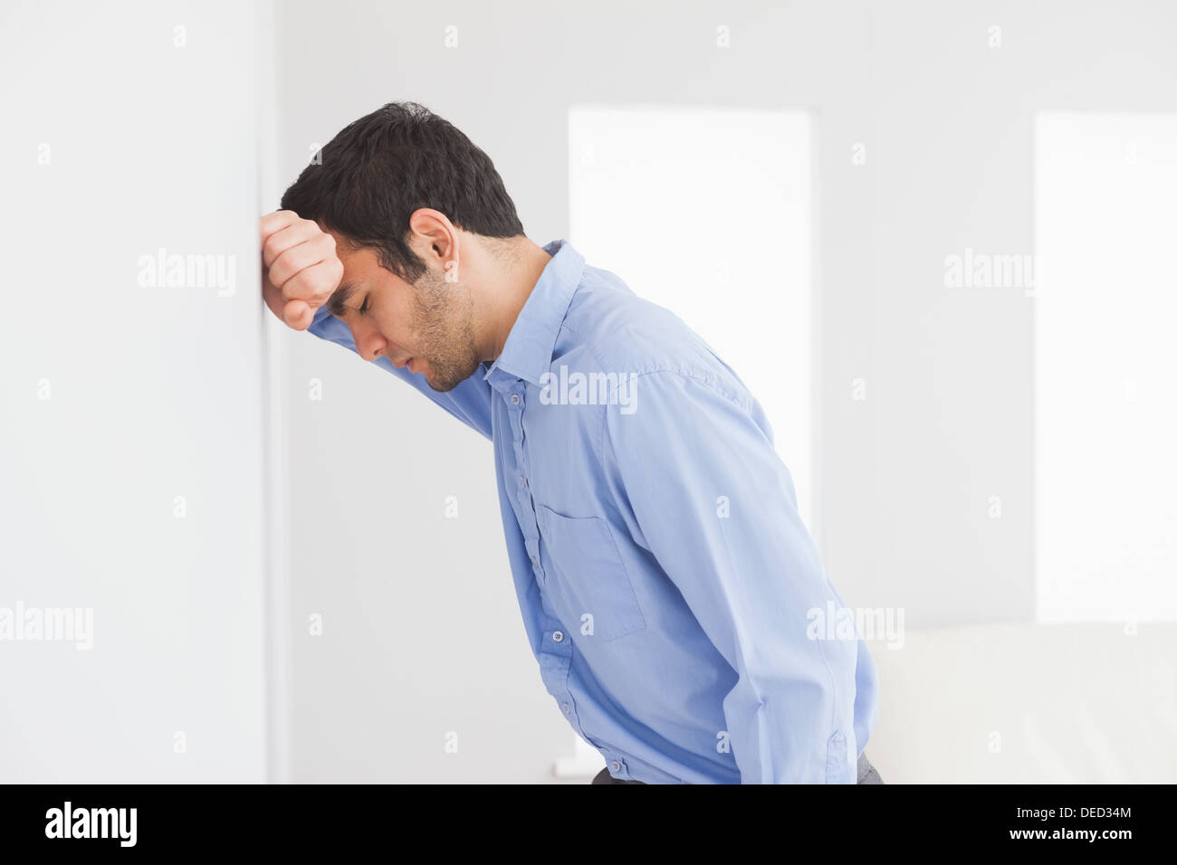 Sad man leaning his head against a wall Stock Photo - Alamy