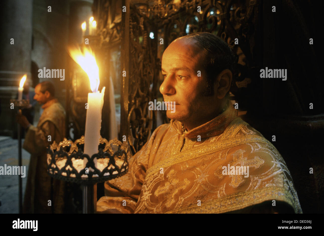 An Arab Orthodox Coptic priest with processional candle at the Holy ...