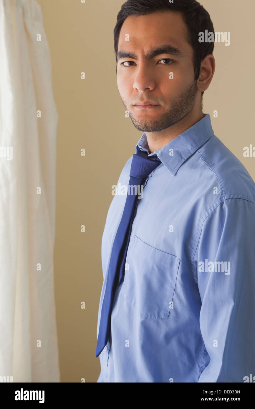 Stern man looking standing in front of window Stock Photo - Alamy