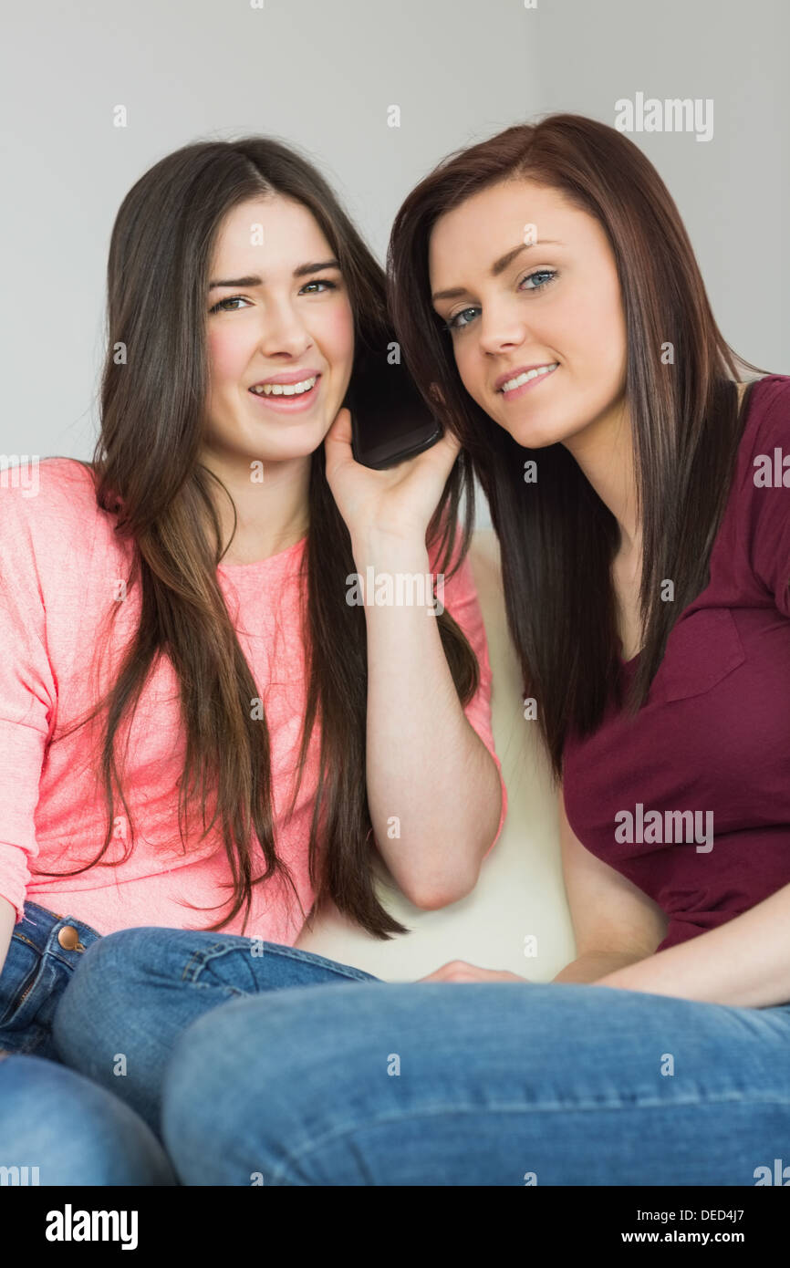 Two pretty girls calling someone withmobile phone Stock Photo - Alamy