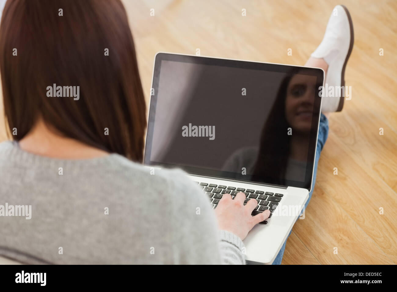 Girl using a laptop sitting on the floor Stock Photo - Alamy