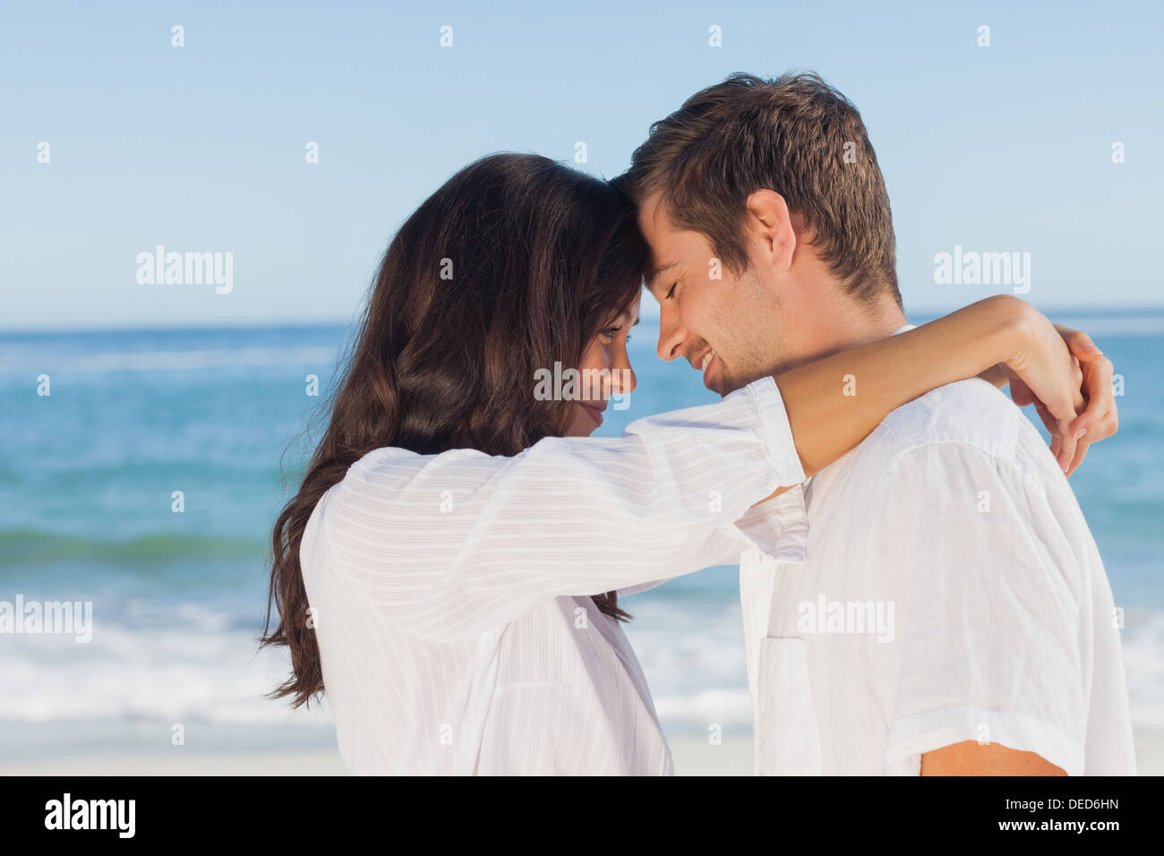 Couple embracing on beach waves hi-res stock photography and images - Alamy