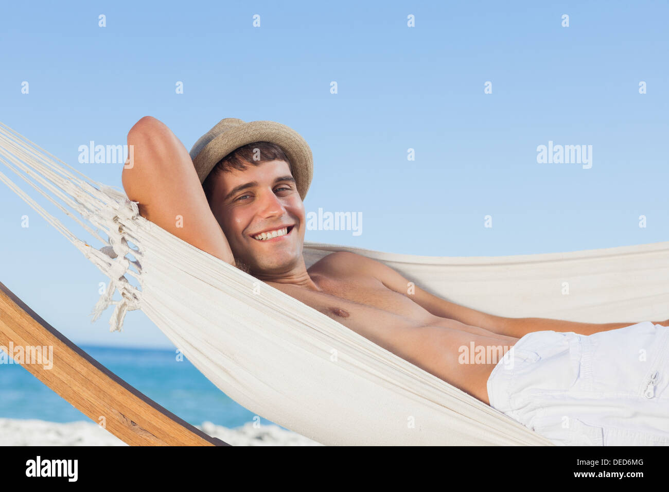 Smiling man wearing straw hat looking Stock Photo - Alamy