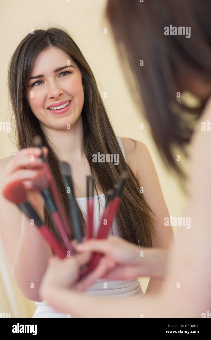 Happy girl choosing a makeup brush at sleepover Stock Photo - Alamy