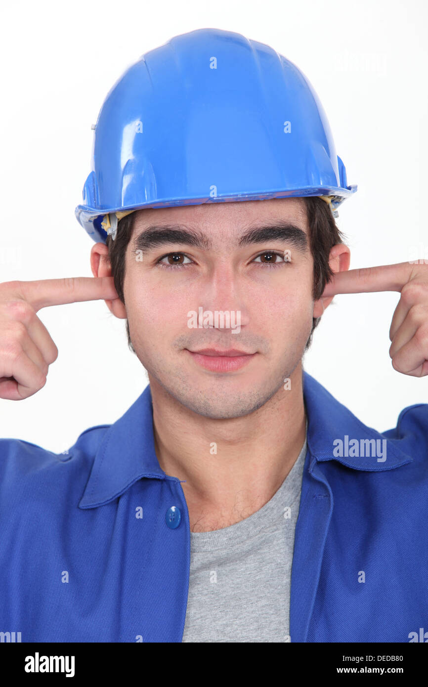 Tradesman plugging his ears Stock Photo - Alamy
