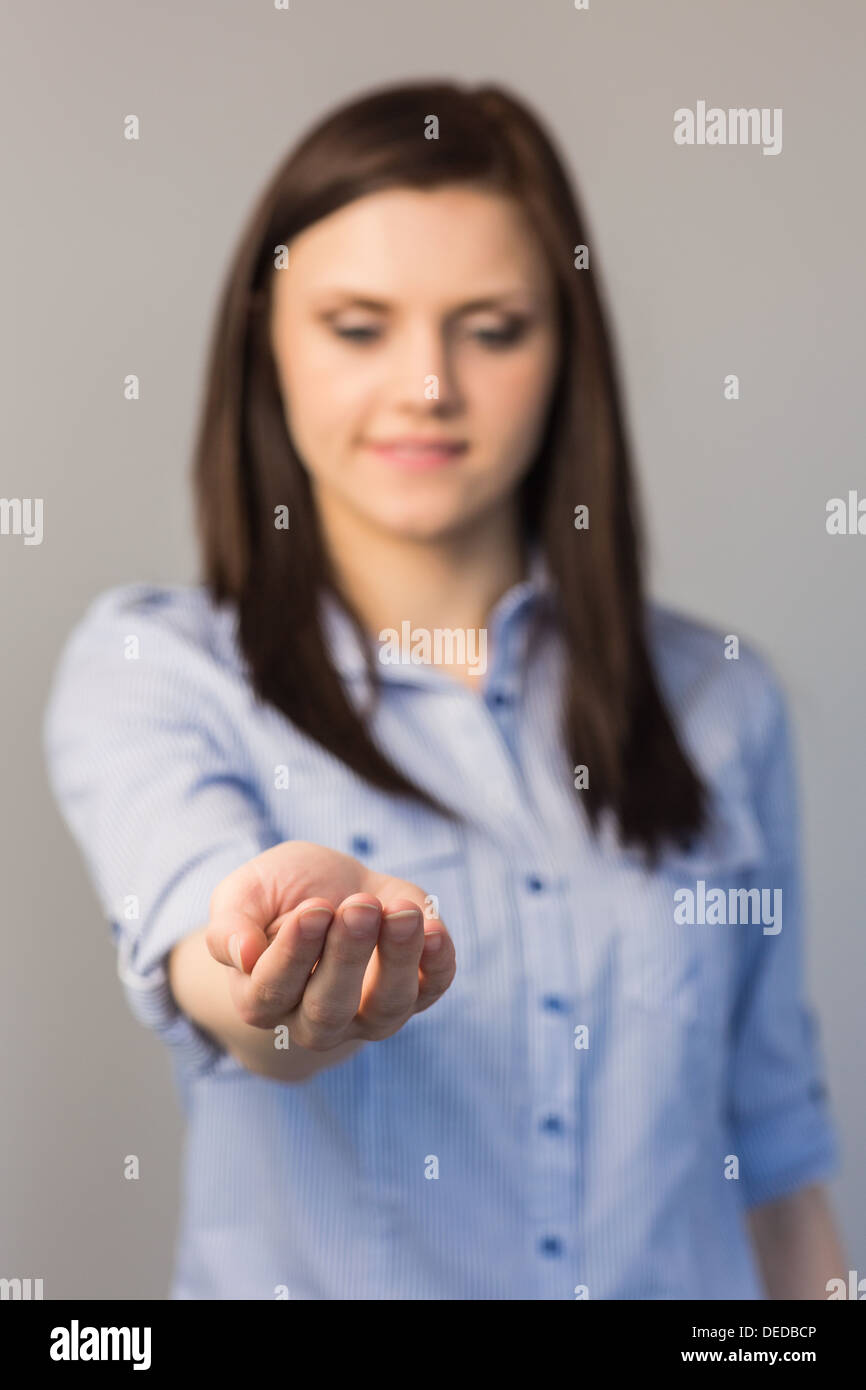 Cheerful pretty brunette presenting her empty hand Stock Photo - Alamy