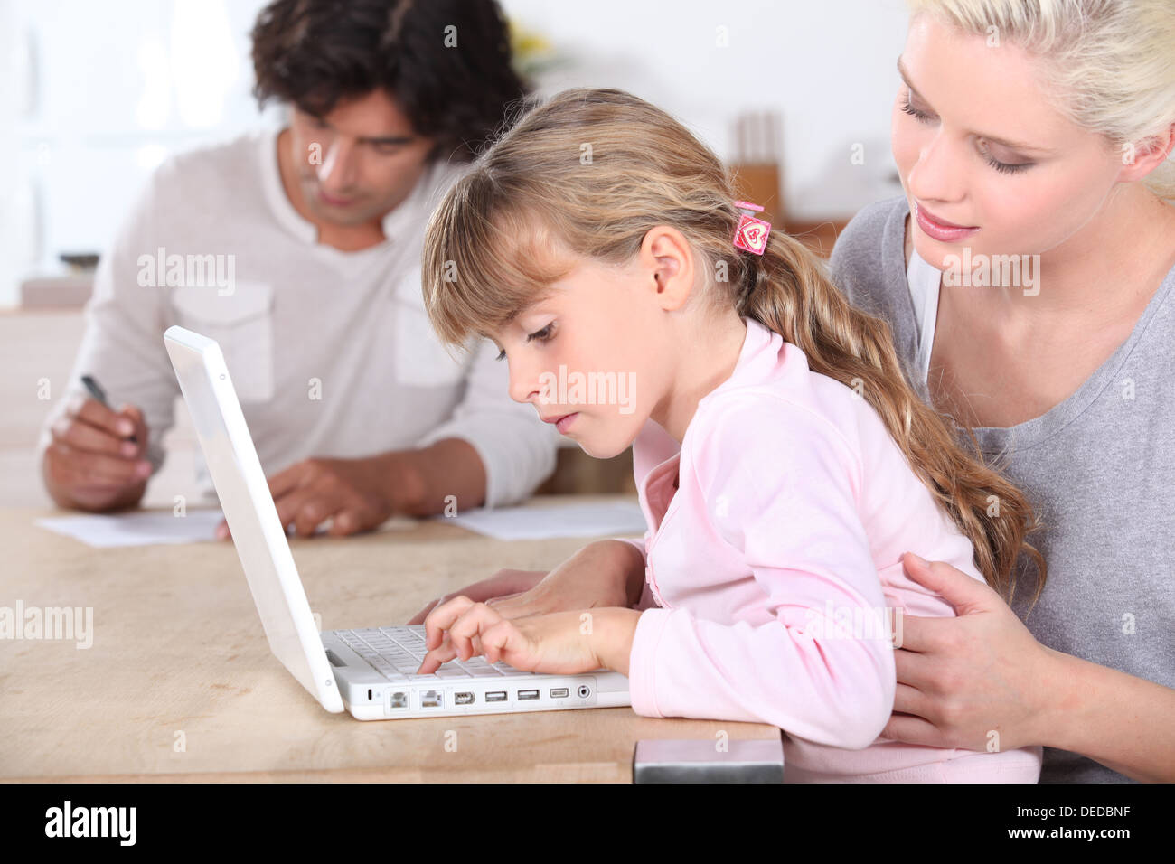 Parents with daughter on computer Stock Photo - Alamy