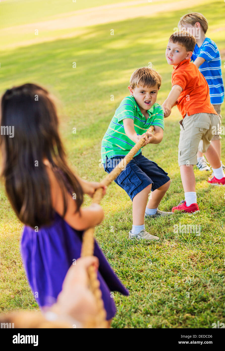 Group of Kids Playing Tug of War On Grass Stock Photo - Alamy