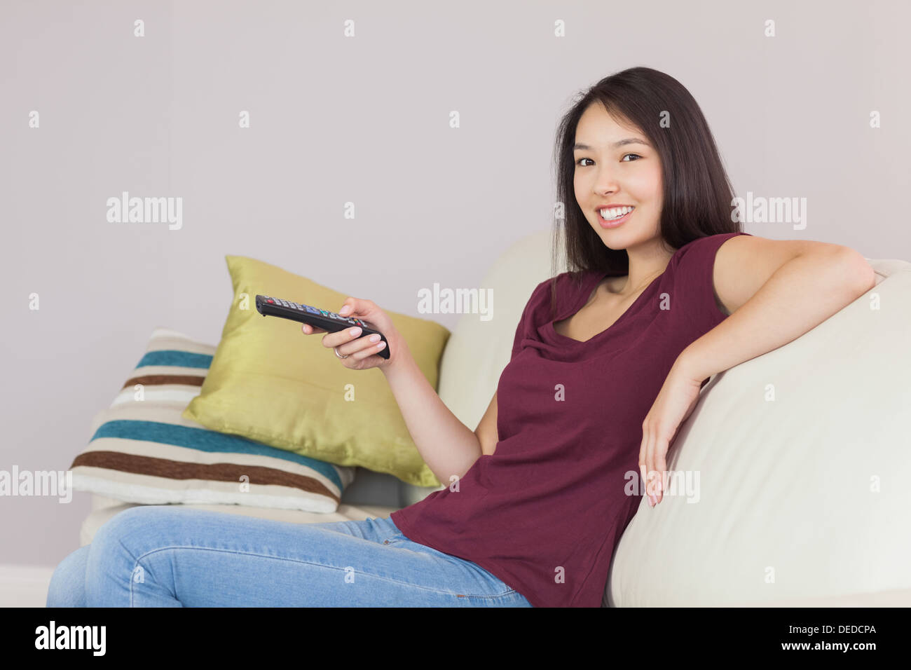 Happy asian girl watching tv smiling Stock Photo - Alamy