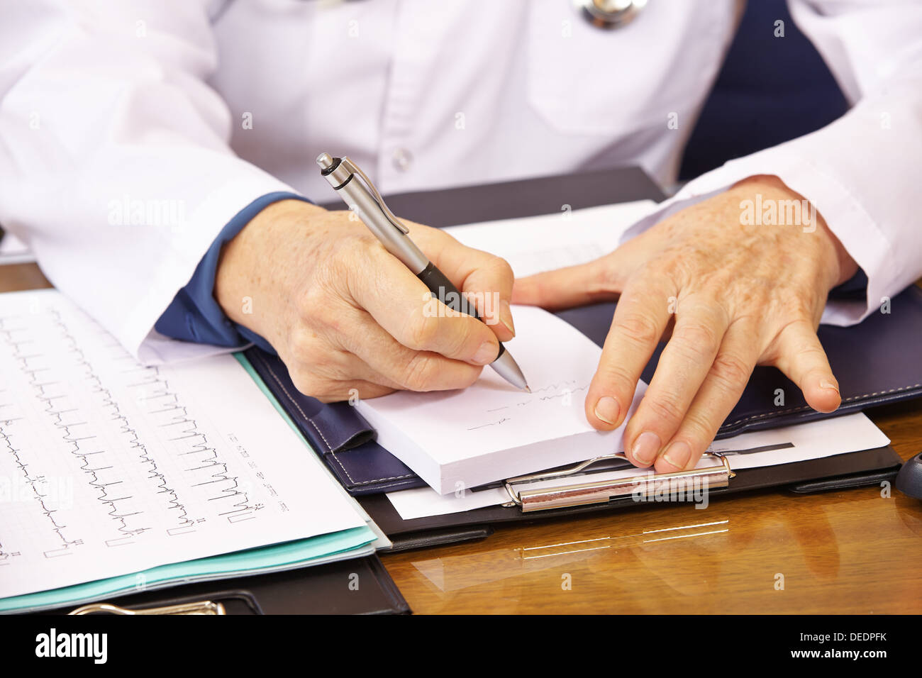 Hand of senior doctor taking notes in office Stock Photo - Alamy