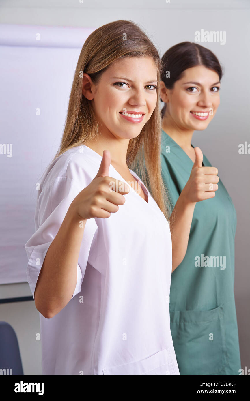Two happy smiling nurses holding their thumbs up Stock Photo - Alamy