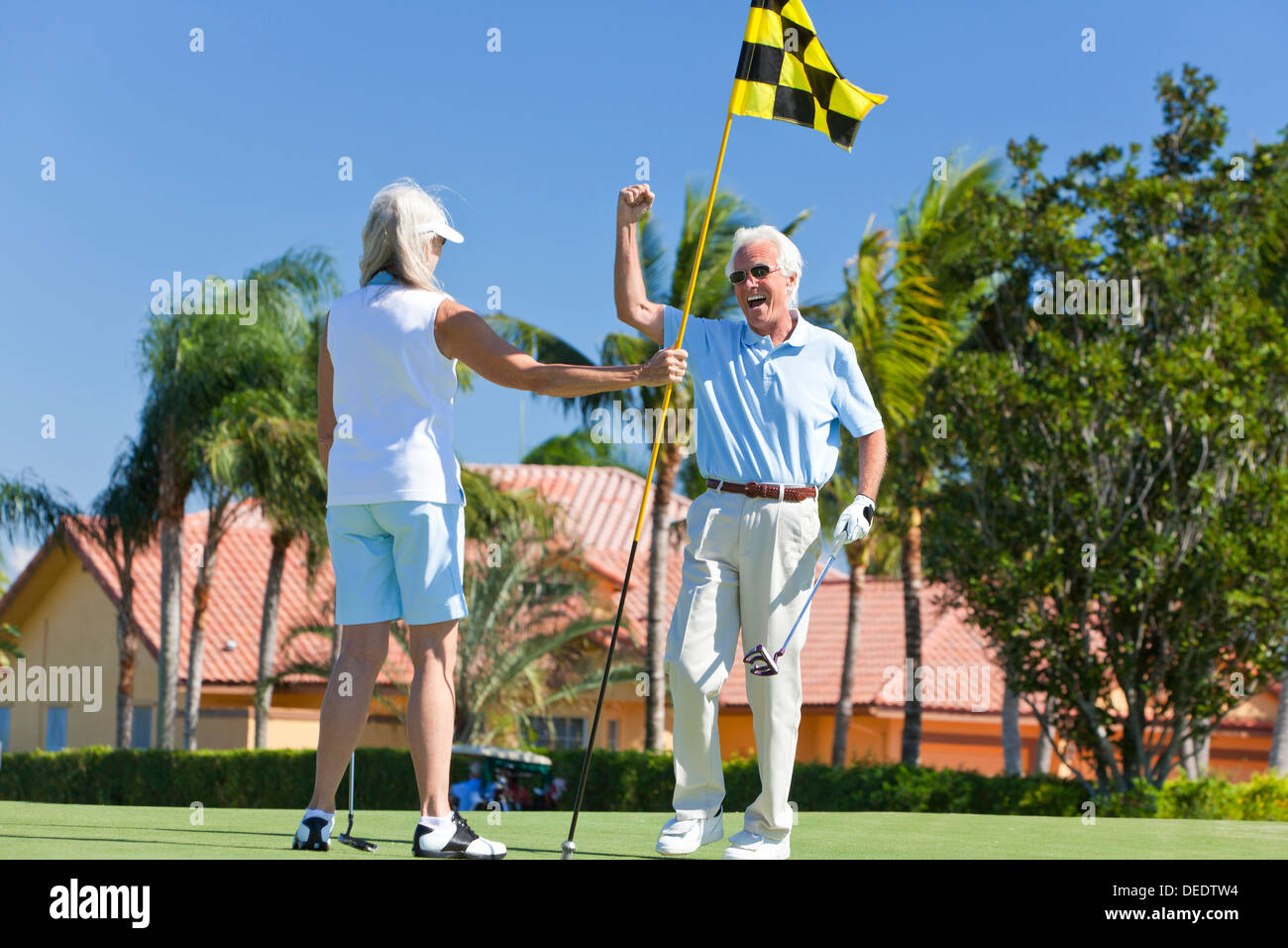 Happy senior man and woman couple together playing golf celebrating on ...