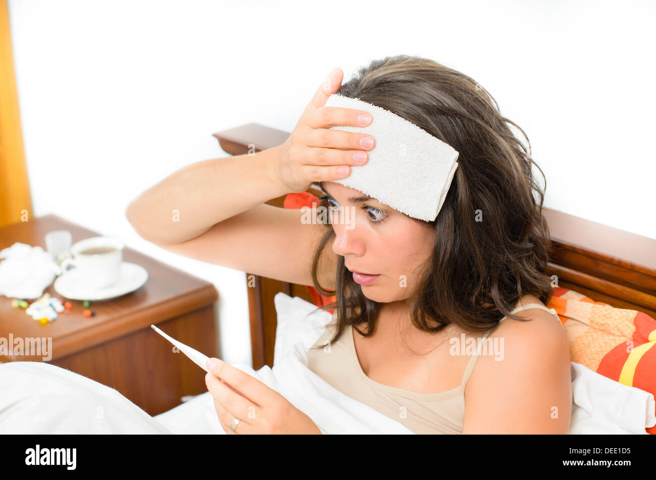 Young woman checking her temperature Stock Photo - Alamy