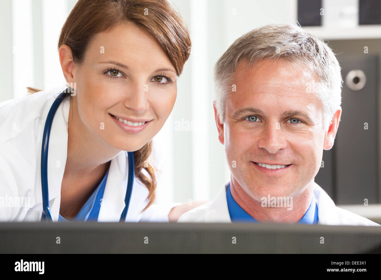 Male & female doctors using computer in a hospital office Stock Photo ...