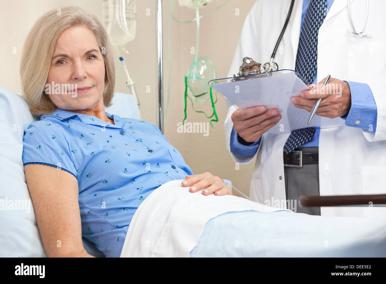 Senior female woman patient in a hospital bed being cared for by a male ...