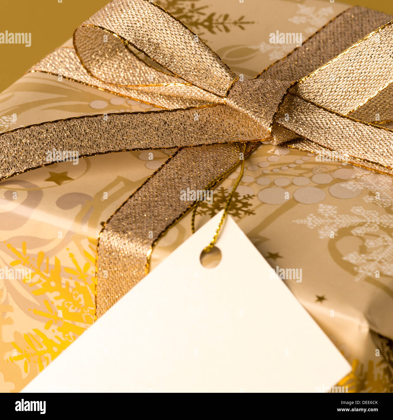 Gold Christmas gift with blank label wishing card Stock Photo - Alamy
