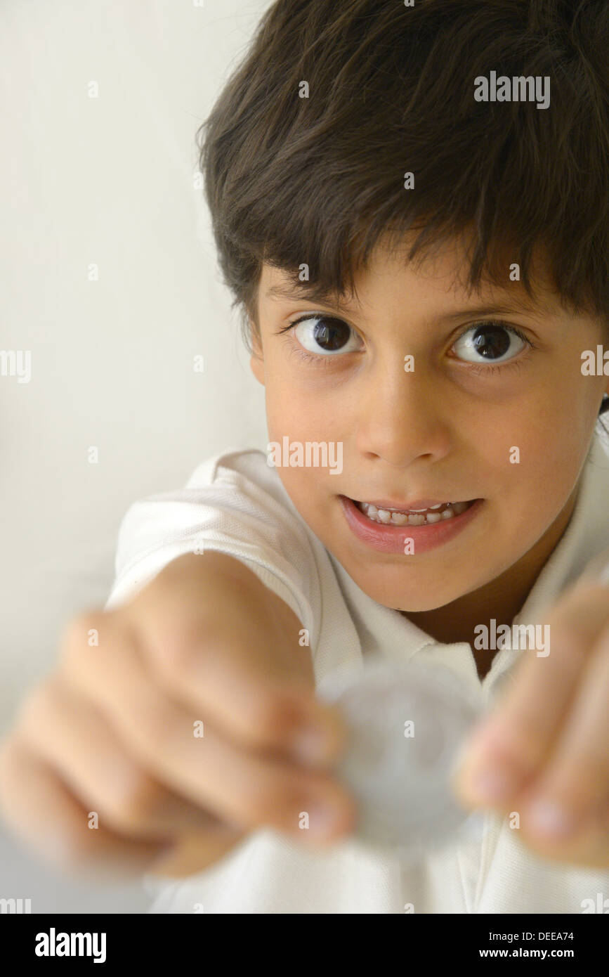Boy holding silver coin Stock Photo - Alamy