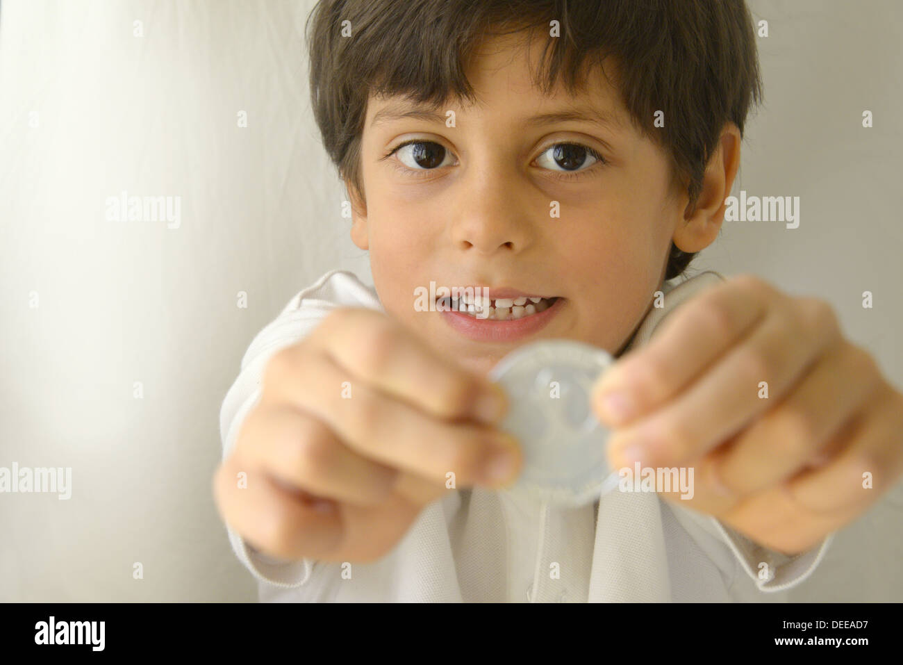 Boy holding silver coin Stock Photo - Alamy