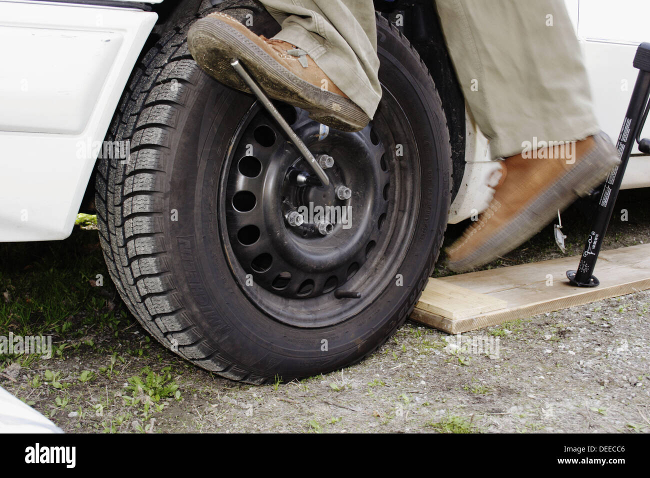 Man loosening the screws of a tire Stock Photo - Alamy