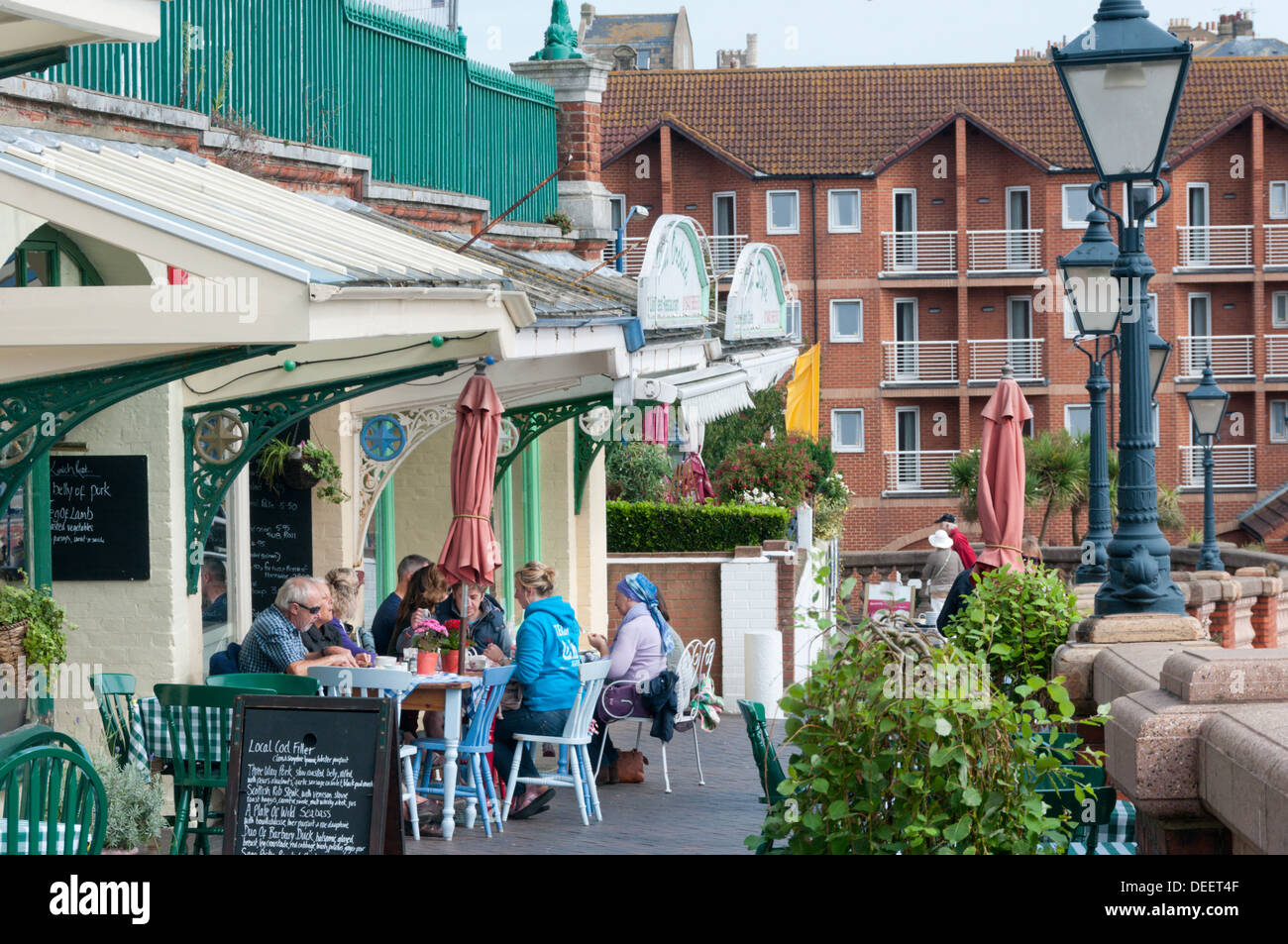 People eating outside cafes and restaurants along West Cliff Arcade ...