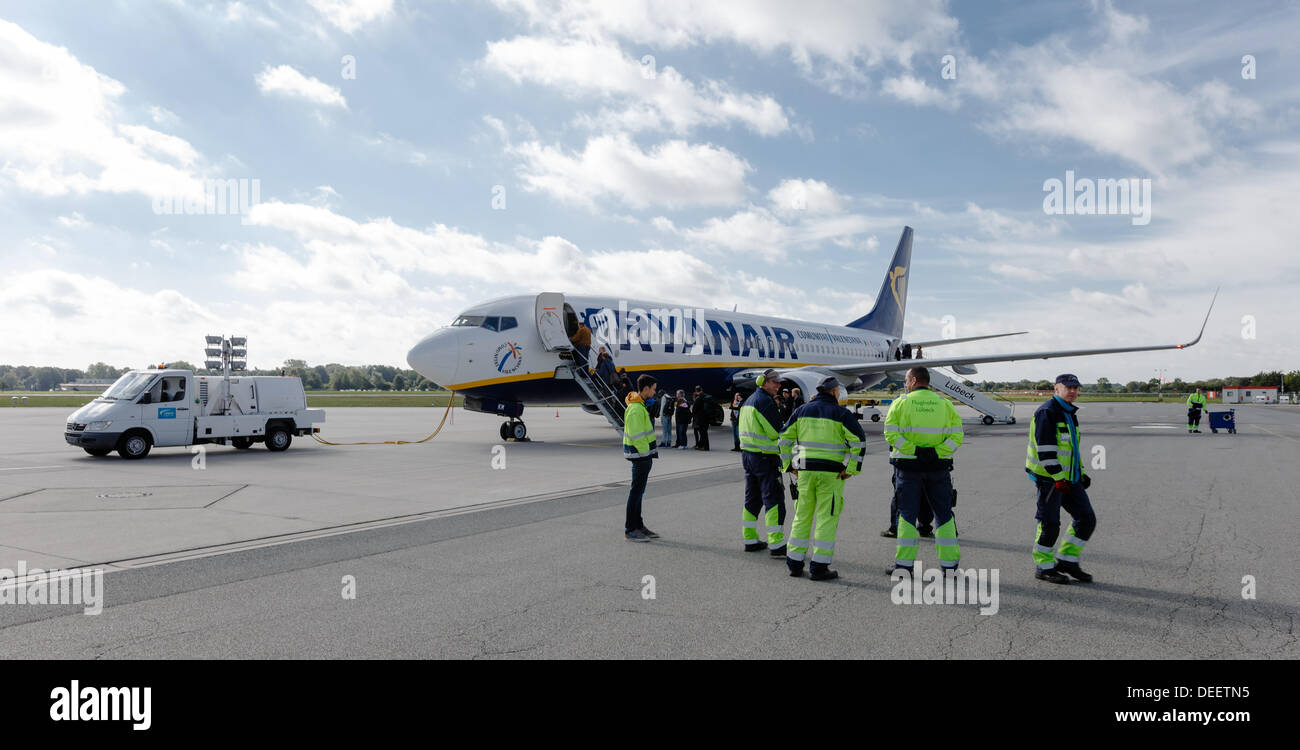 Airport employees atnd in front of a Ryanair machine at the airport ...