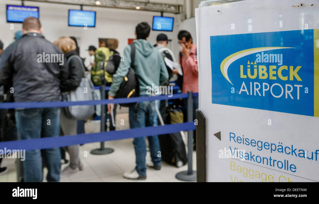 Passengers of a Ryanair flight queue at a check-in desk at the airport ...