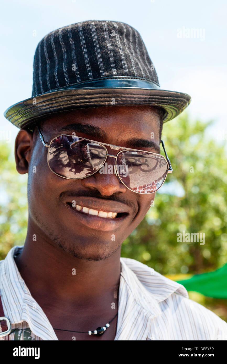 Africa, Angola, Benguela. Portrait of young man in hat and sunglasses ...