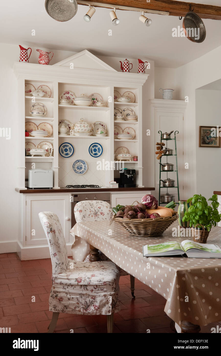 Farmhouse kitchen with ceramics display and spotted tablecloth Stock ...