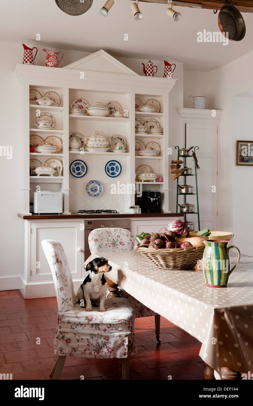 Farmhouse kitchen with ceramics display and spotted tablecloth Stock ...