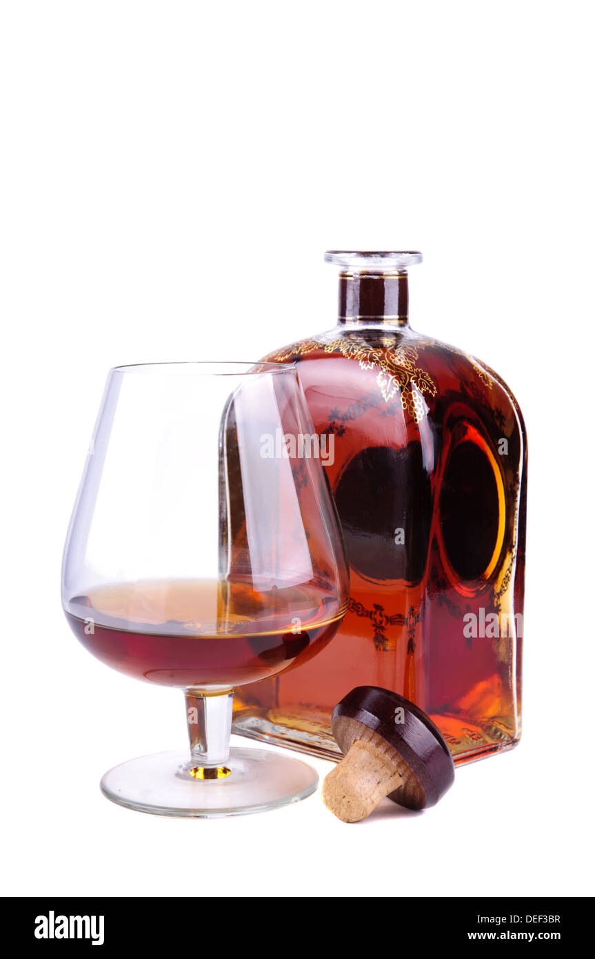 glass and bottle of cognac or brandy with cork isolated on a white ...