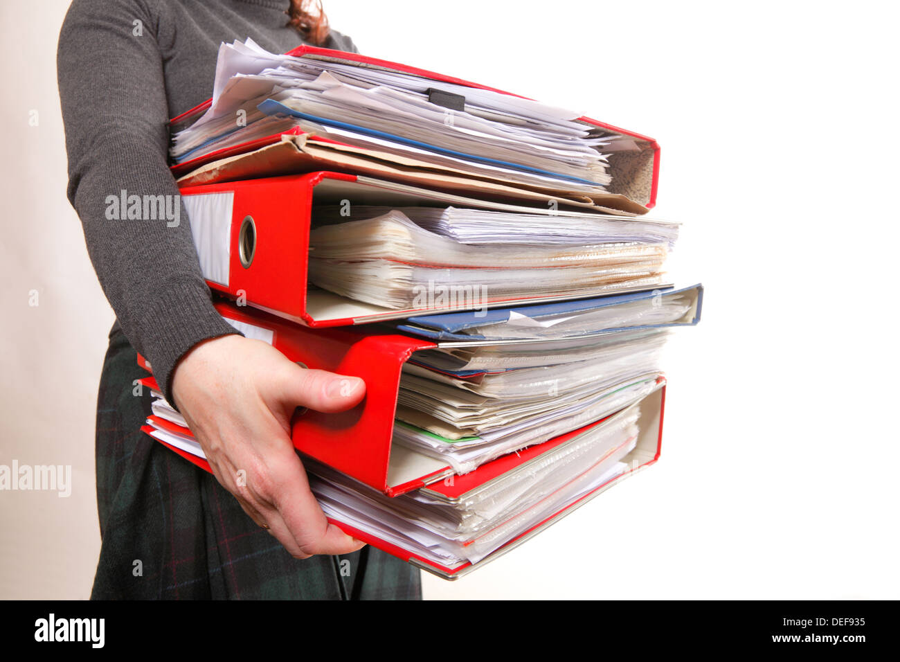 woman in grey holding stack of folders. Pile with old documents and ...