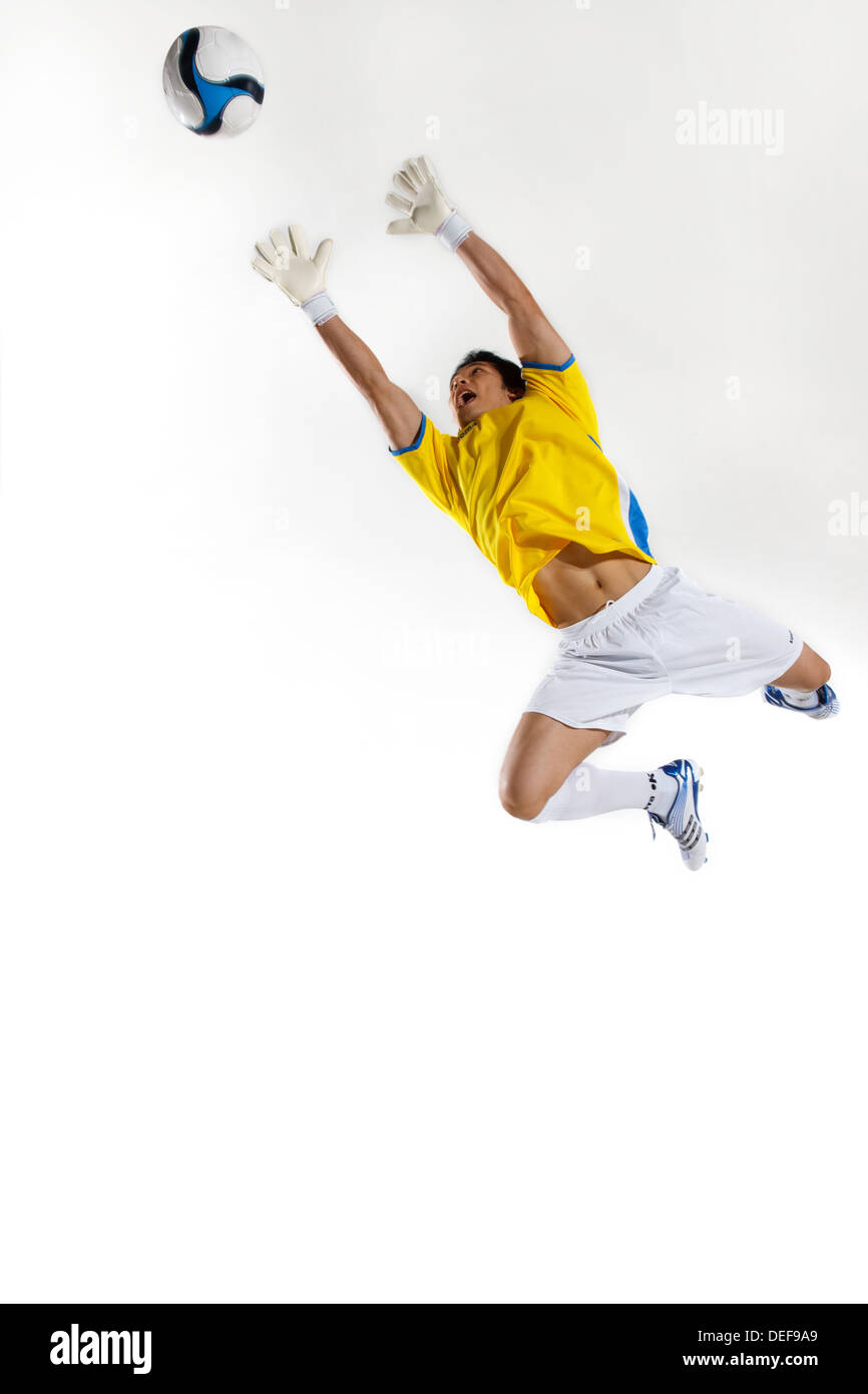Young man playing football Stock Photo - Alamy