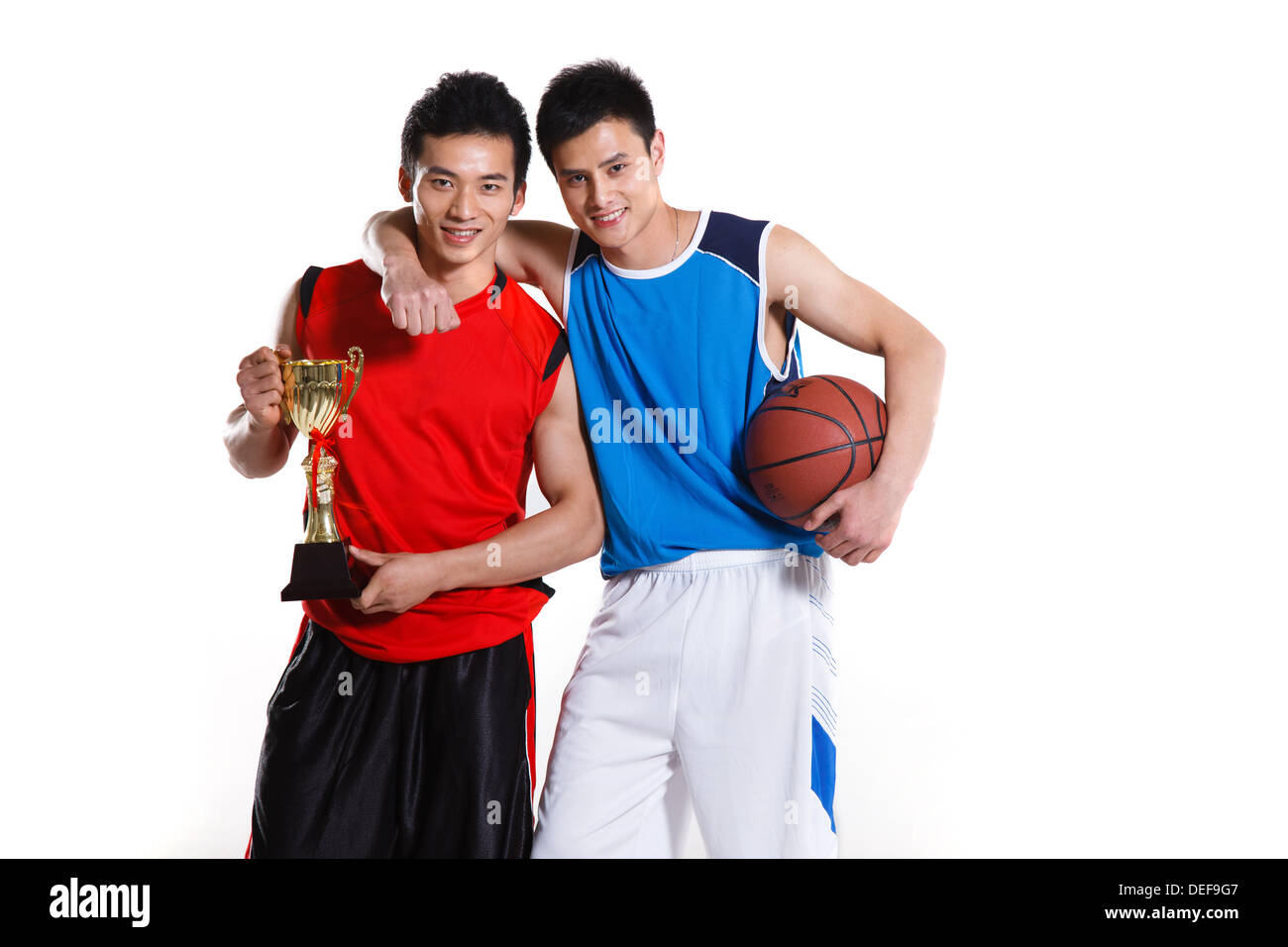 Male athletes holding trophy and basketball Stock Photo - Alamy
