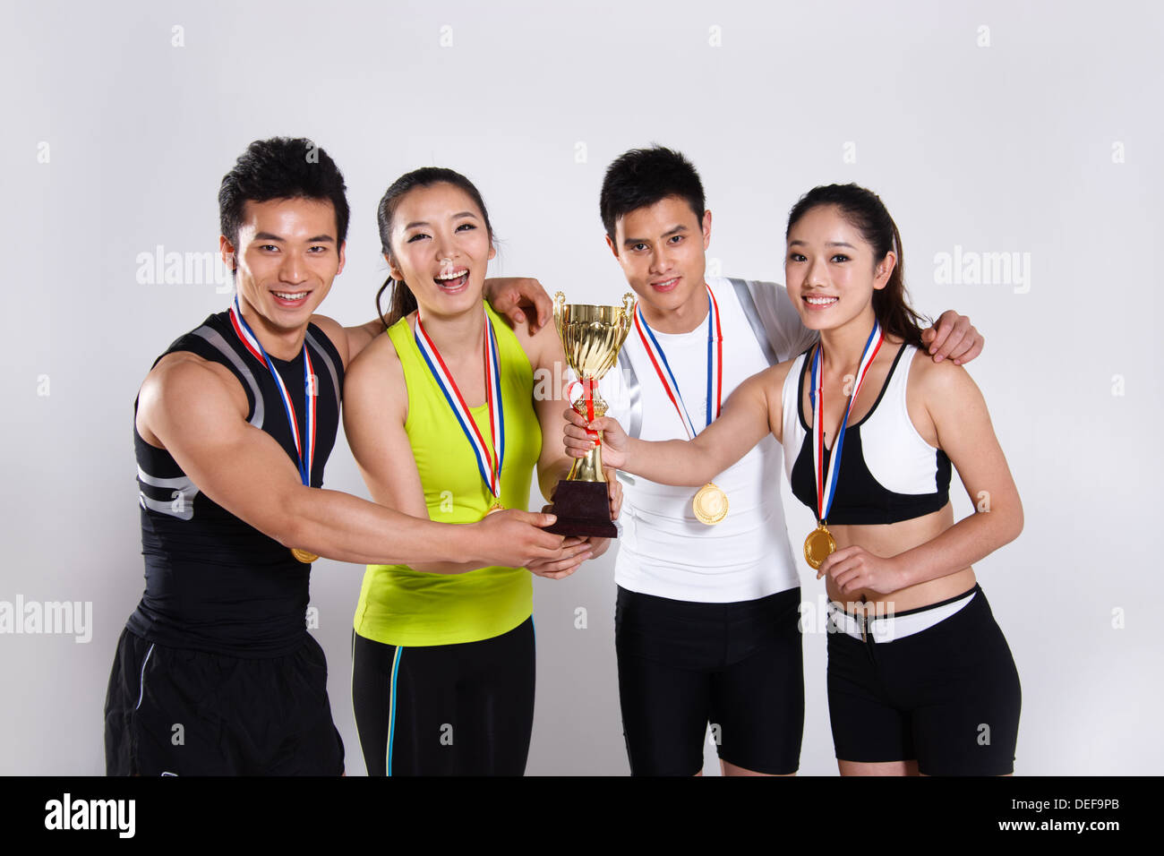 Group of young athletes holding trophy Stock Photo - Alamy