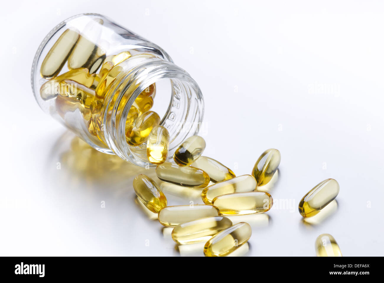 Fish oil spilling from bottle Stock Photo - Alamy