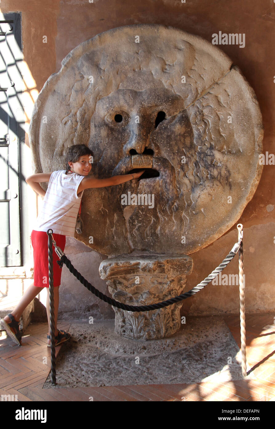 cheerful young boy inserts his hand into the Bocca della Verità, Rome ...