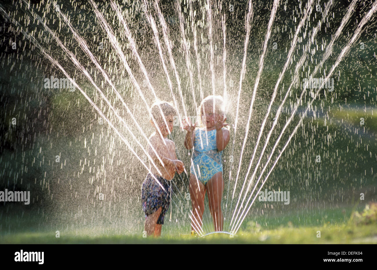 Boy playing in lawn sprinkler hi-res stock photography and images - Alamy