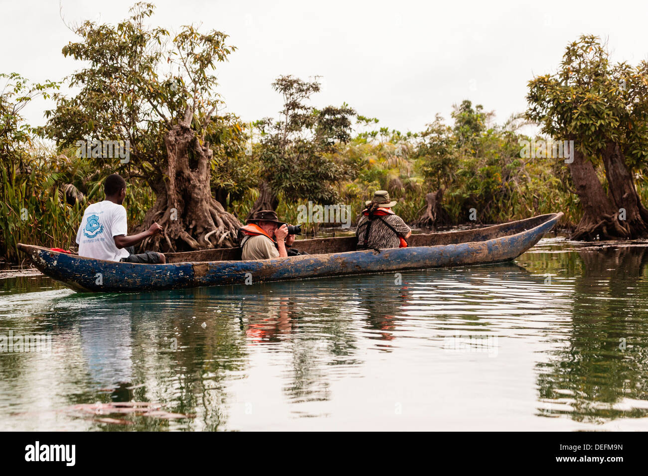 Africa, Liberia, Monrovia. Tourist taking picture from traditional ...