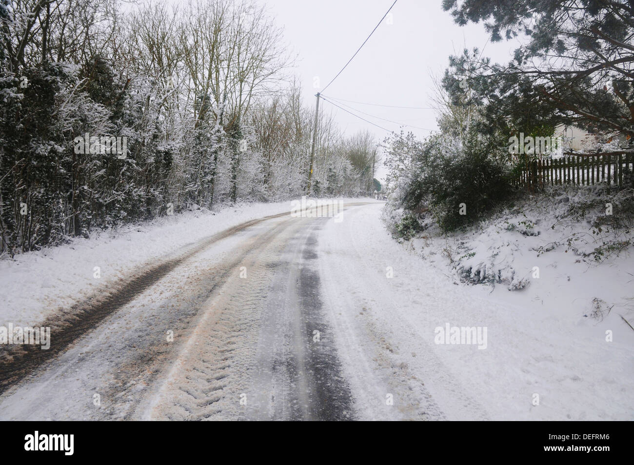 snow and slush on bend of narrow county road Stock Photo - Alamy