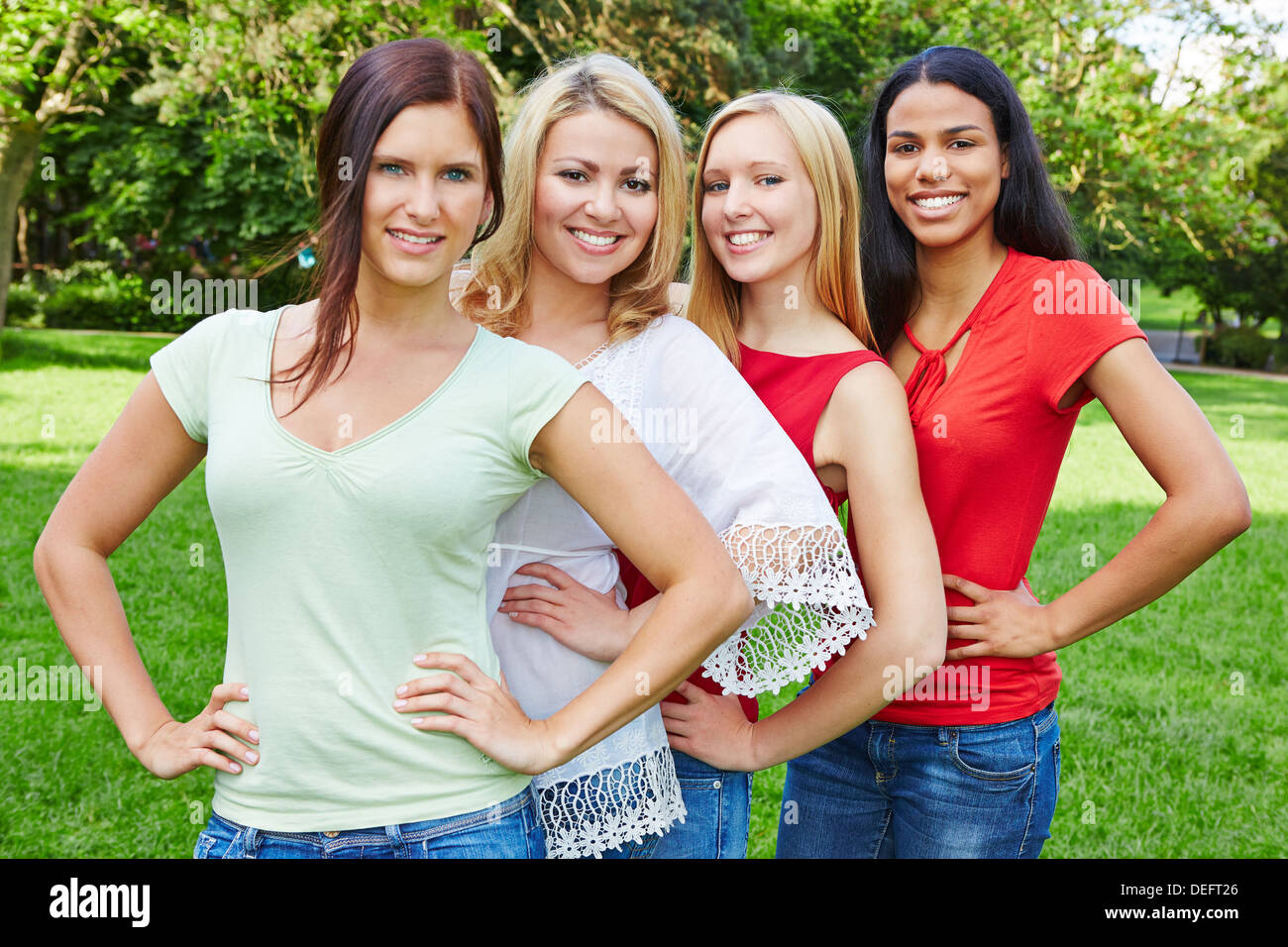 Group of four happy women smiling together in nature Stock Photo - Alamy