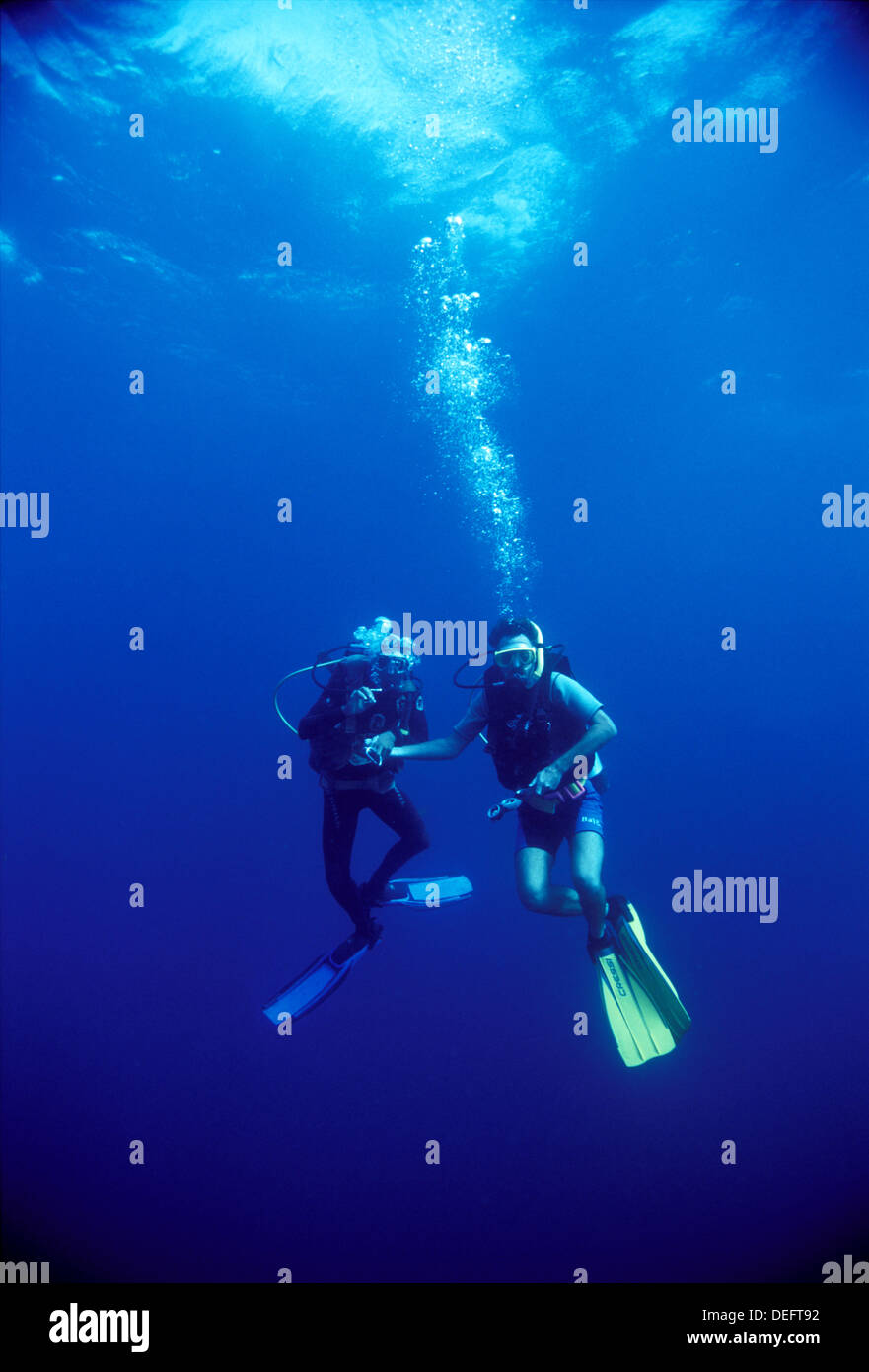 Two divers emerging from deep blue. Archipelago of Raja Ampat. Papua ...