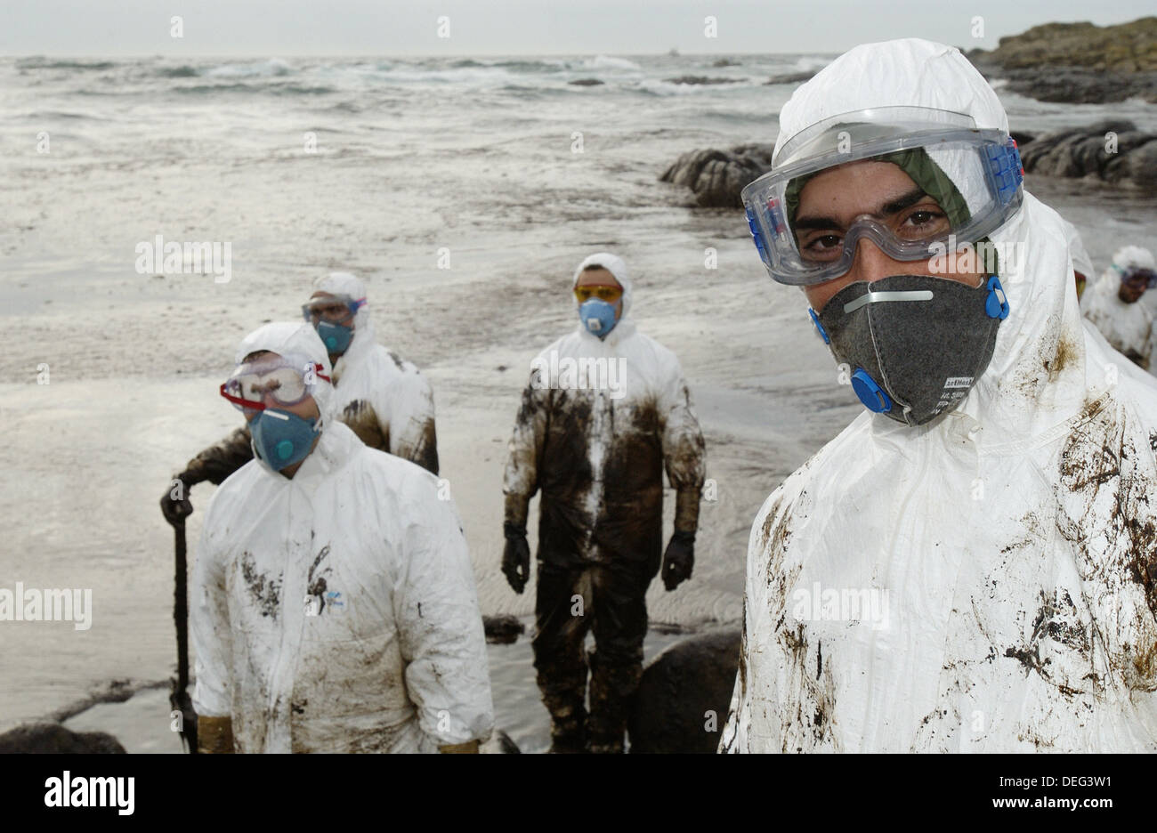 Soldiers dressed with protective clothing cleaning up the oil spill ...