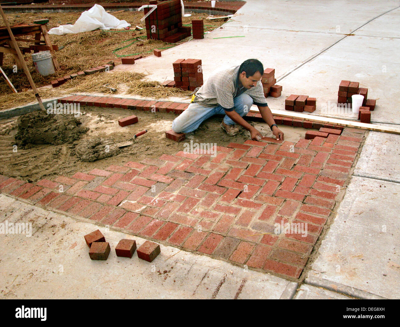Hispanic bricklayer laying driveway Stock Photo - Alamy