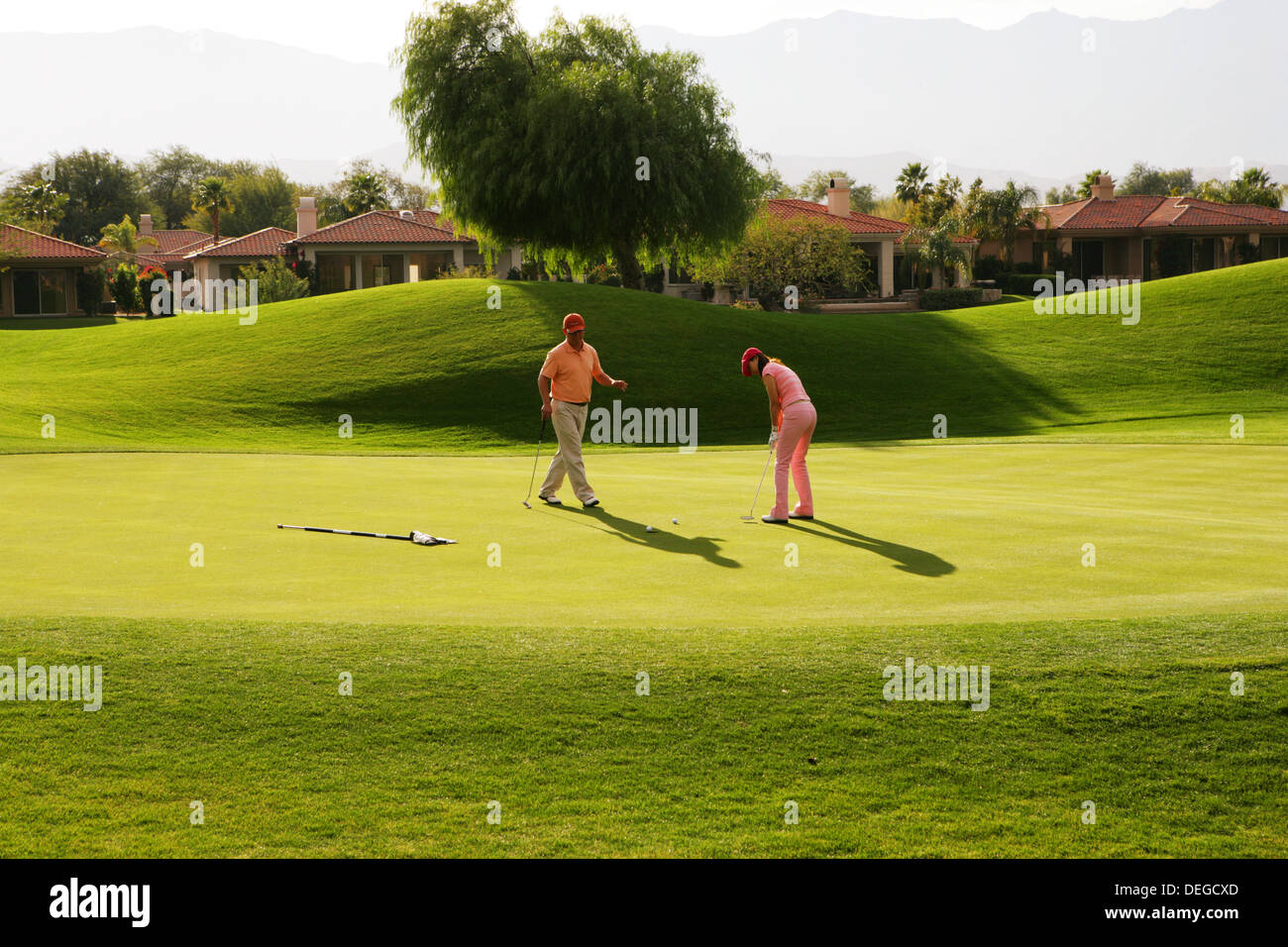 Two Chinese people playing golf Stock Photo - Alamy