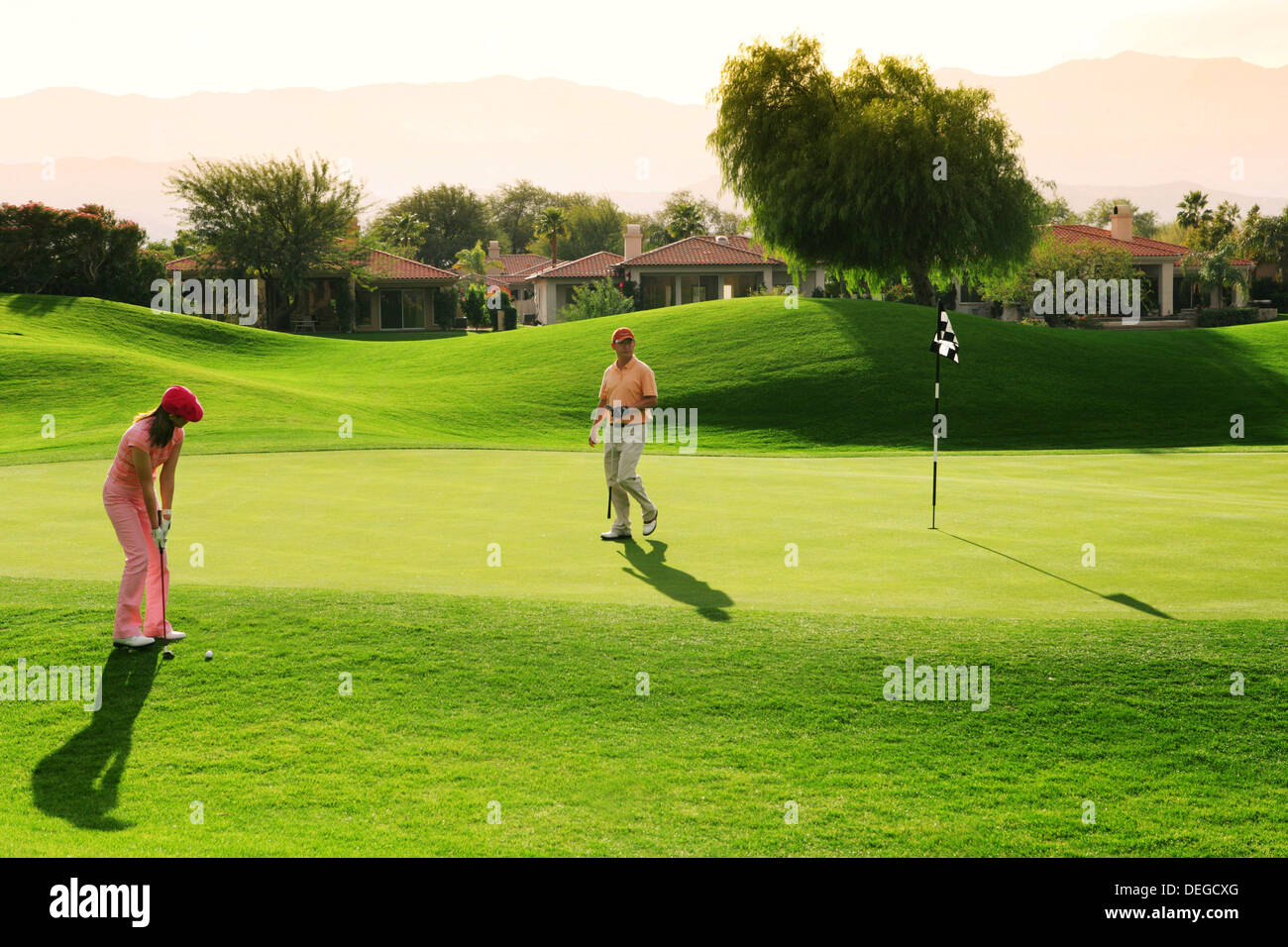 Two Chinese people playing golf Stock Photo - Alamy