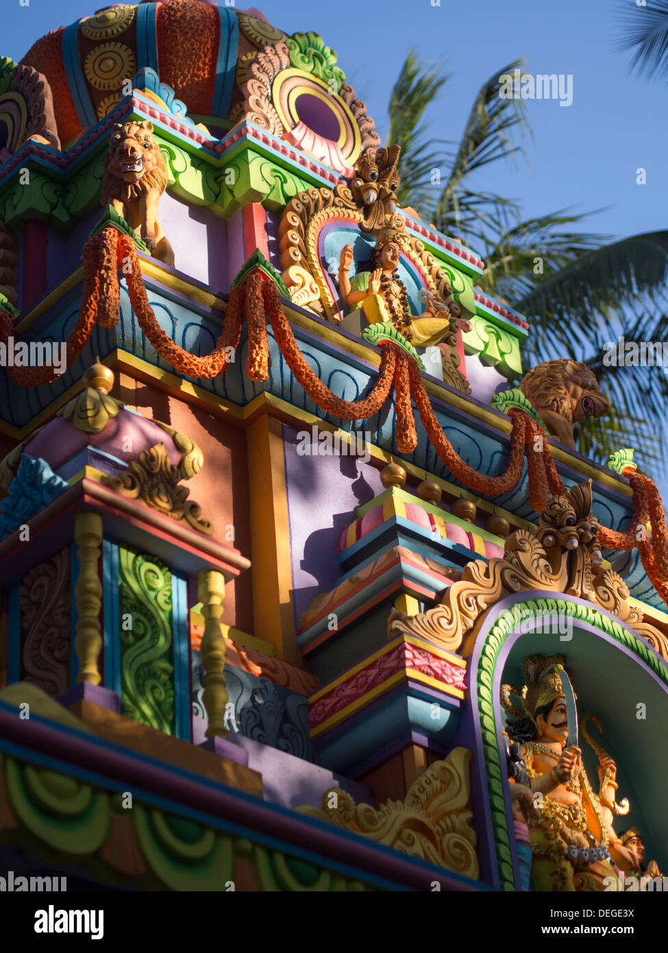 A colorful Hindu temple is decorated with colors and flower wreaths in ...
